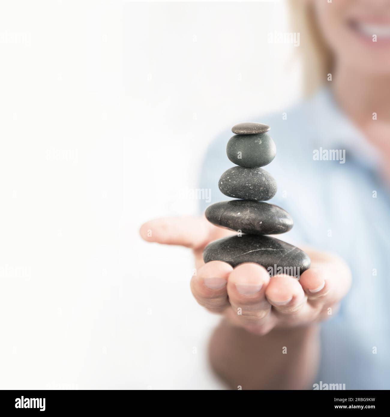 Woman balancing stones Stock Photo - Alamy