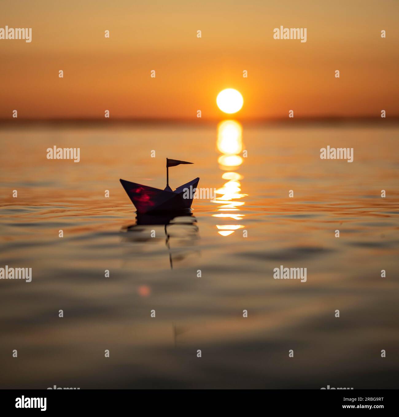 Paper ship in the sunset Stock Photo - Alamy