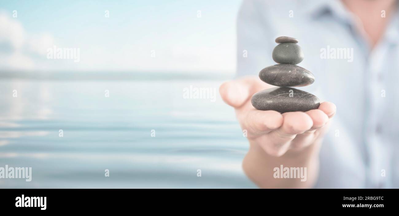 Person holding a stack of stones Stock Photo - Alamy