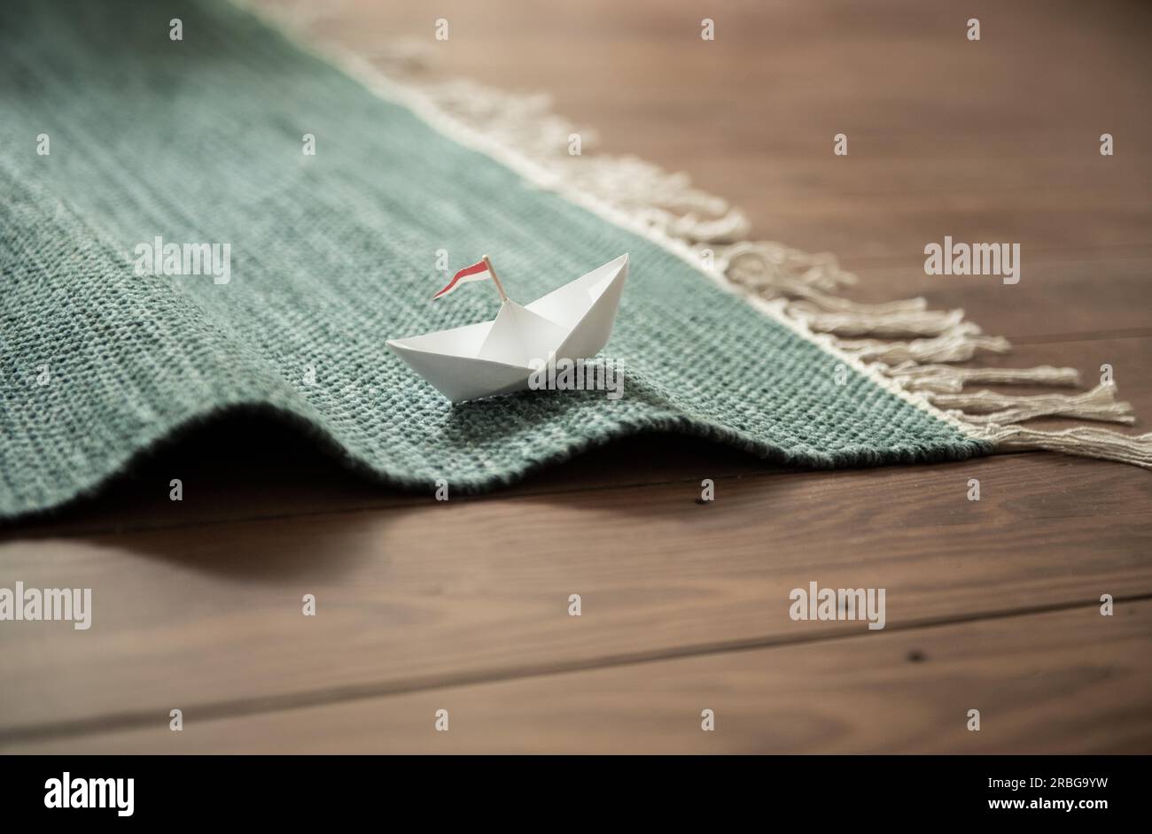 Paper ship on carpet waves Stock Photo - Alamy