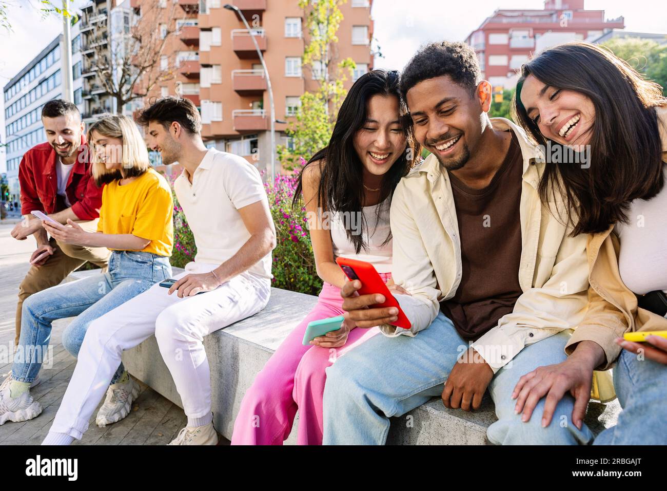 Group of young net generation friends having fun using cellphones ...