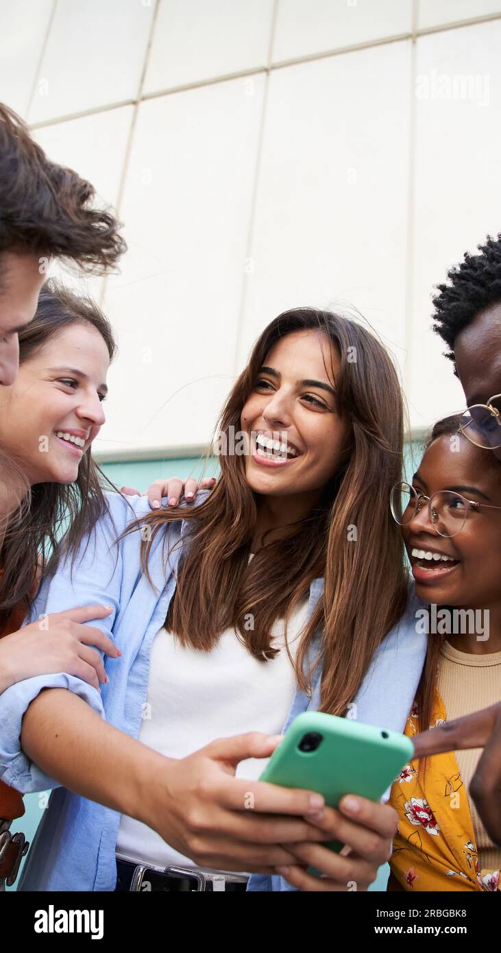 Diverse university students watching smartphones in college campus ...