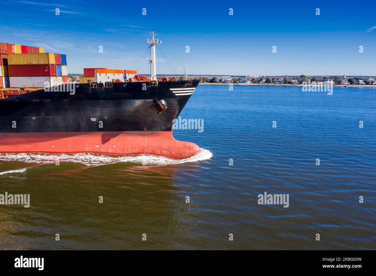 A cargo ship steams towards the open ocean out of a harbor Stock Photo ...