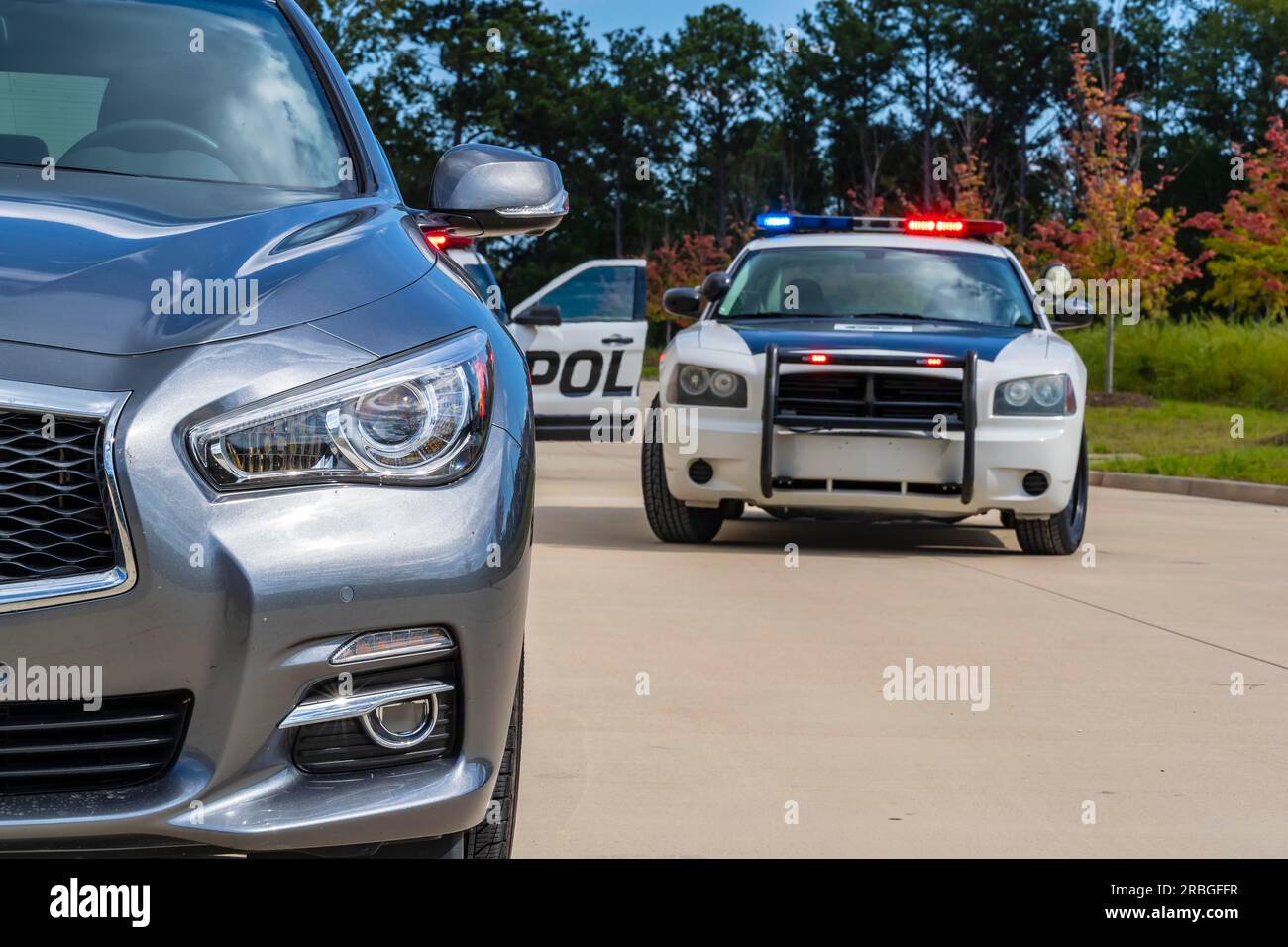 Two police vehicles stop a sedan on a routine traffic stop Stock Photo ...