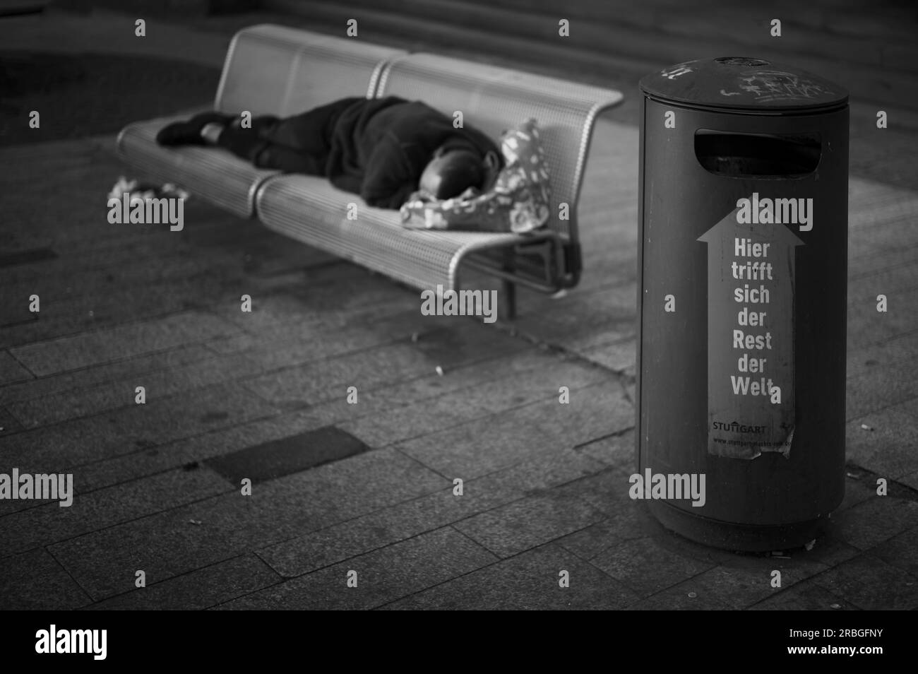 Homeless man, Berber, lying on park bench, sleeping, in front of it ...