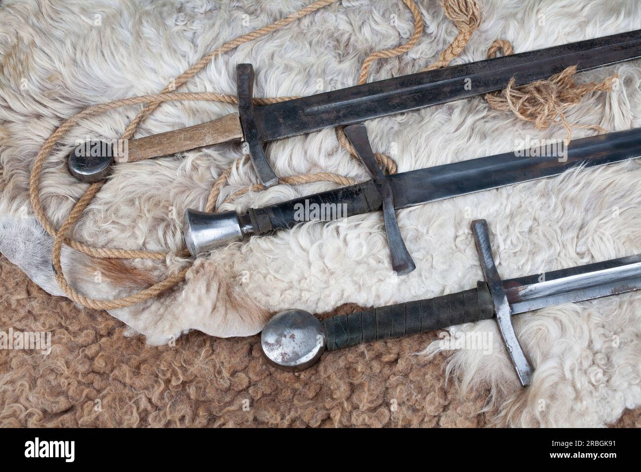 Medieval swords on sheep fur background Stock Photo - Alamy