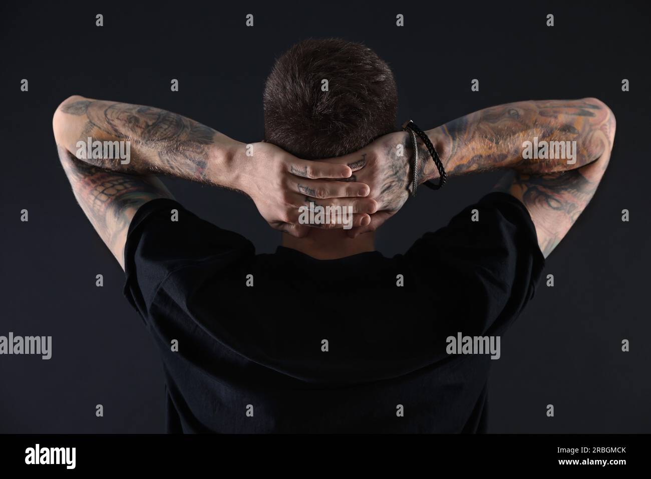 Handsome hipster man posing on black background, back view Stock Photo ...