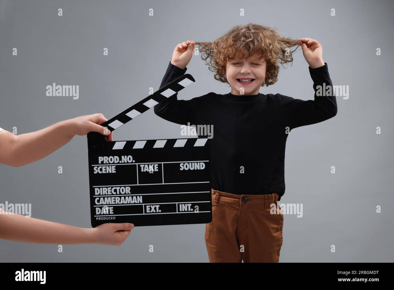 Happy cute boy performing while second assistant camera holding ...