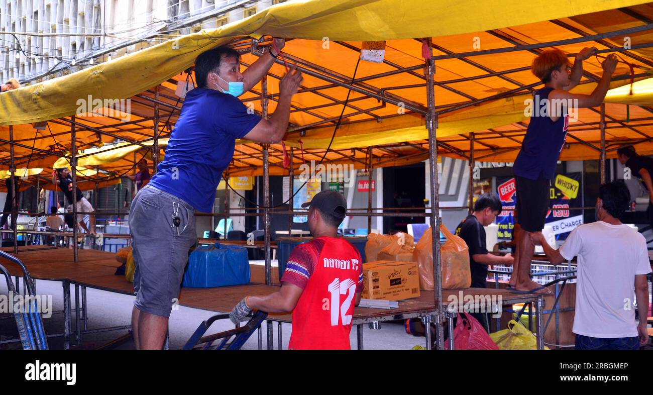Young men assemble the stall structures of Patong Night Market, on Patpong Road 1, in Silom ...