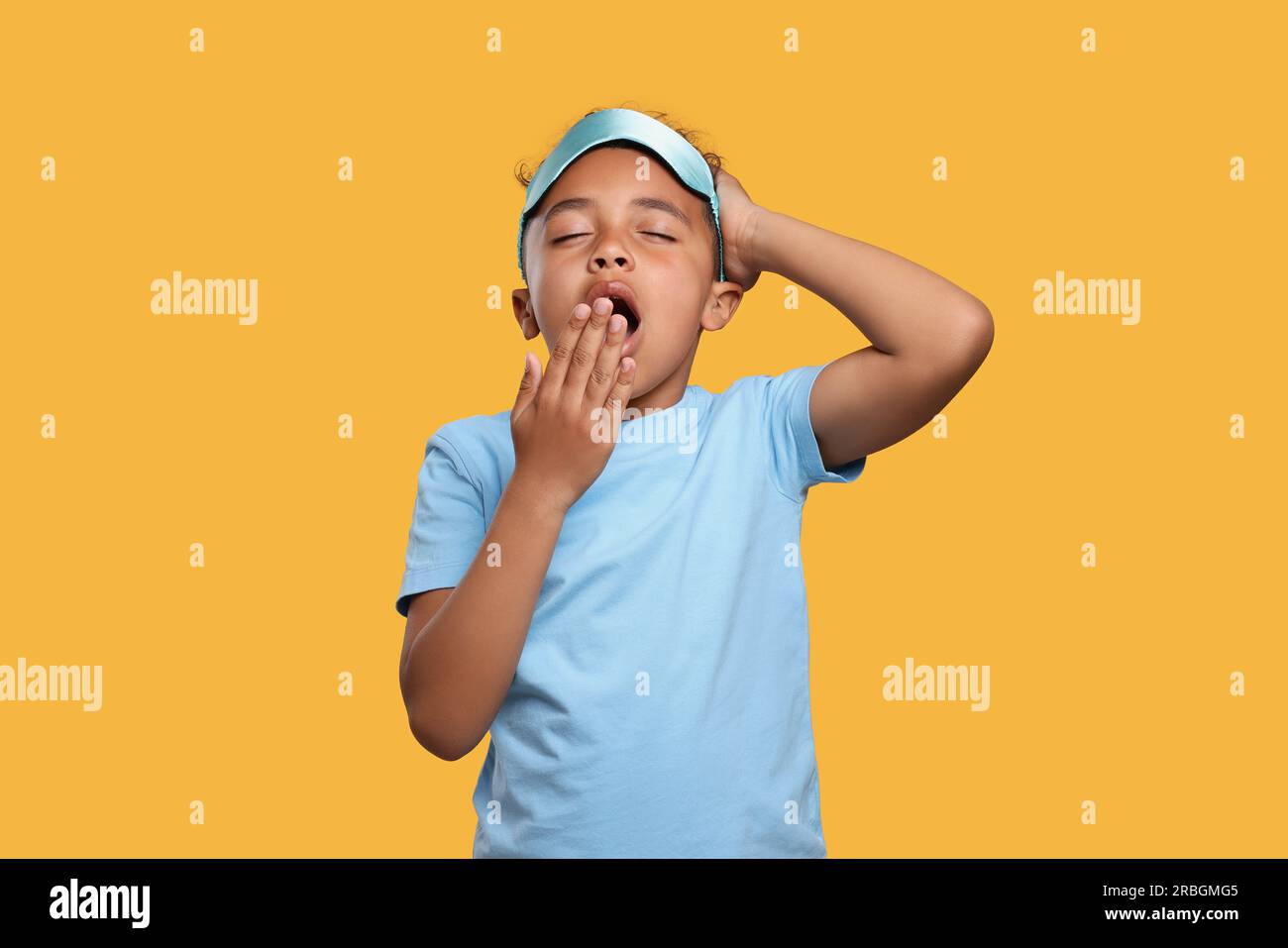 Boy with sleep mask yawning on yellow background. Insomnia problem ...