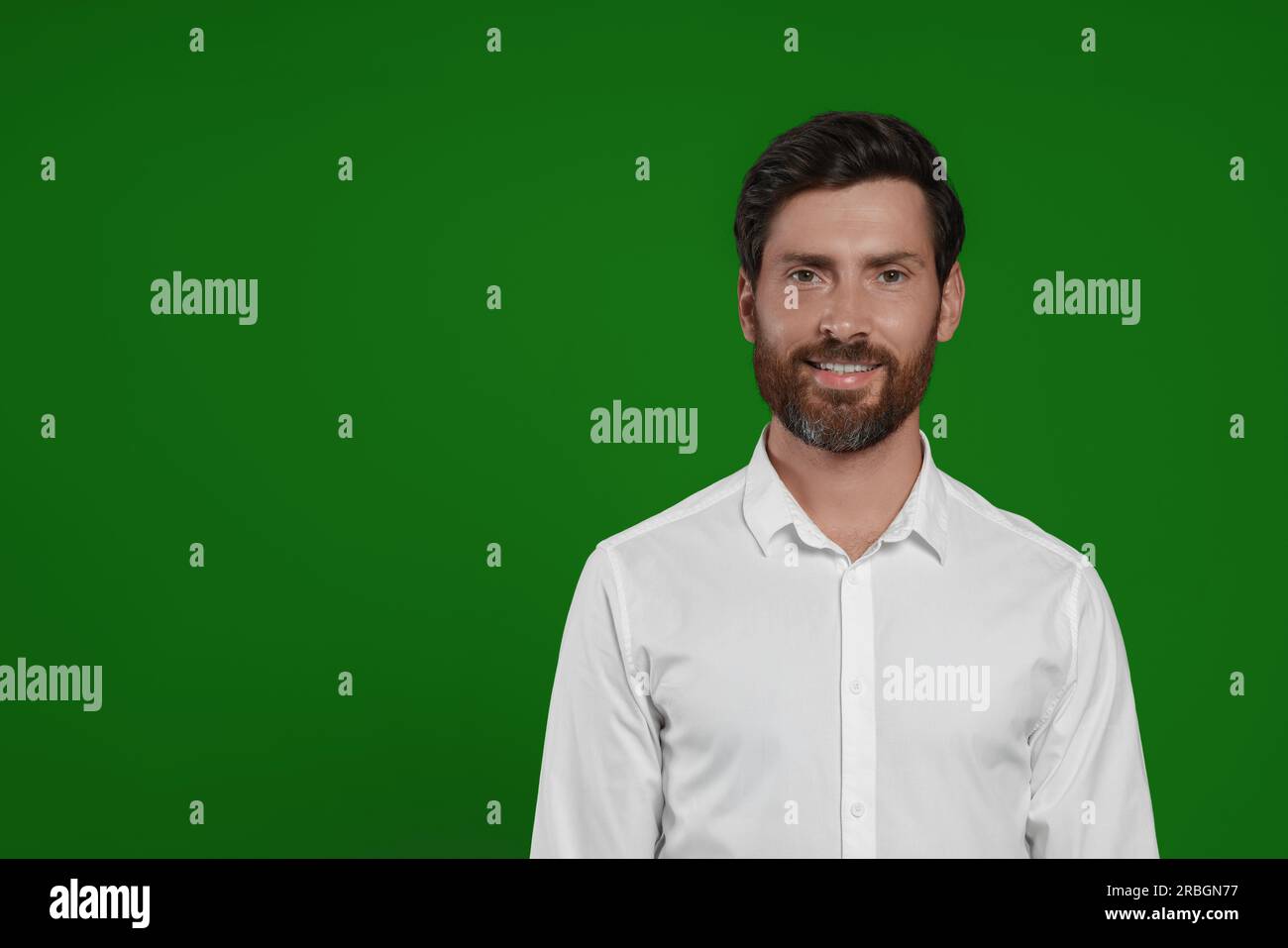 Chroma key compositing. Handsome man smiling against green screen Stock ...