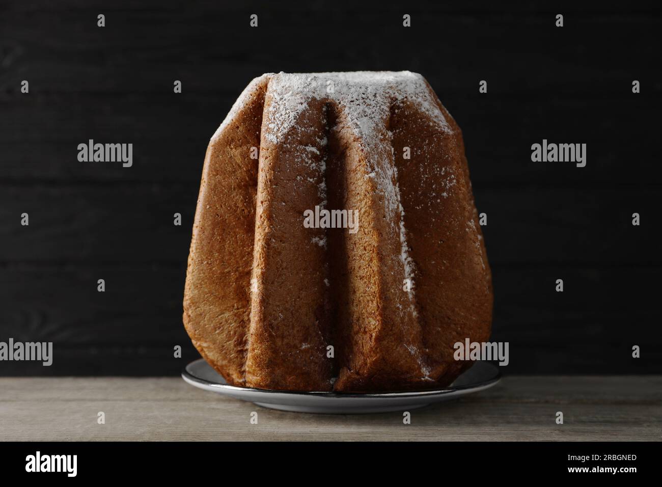 Delicious Pandoro cake decorated with powdered sugar on wooden table ...