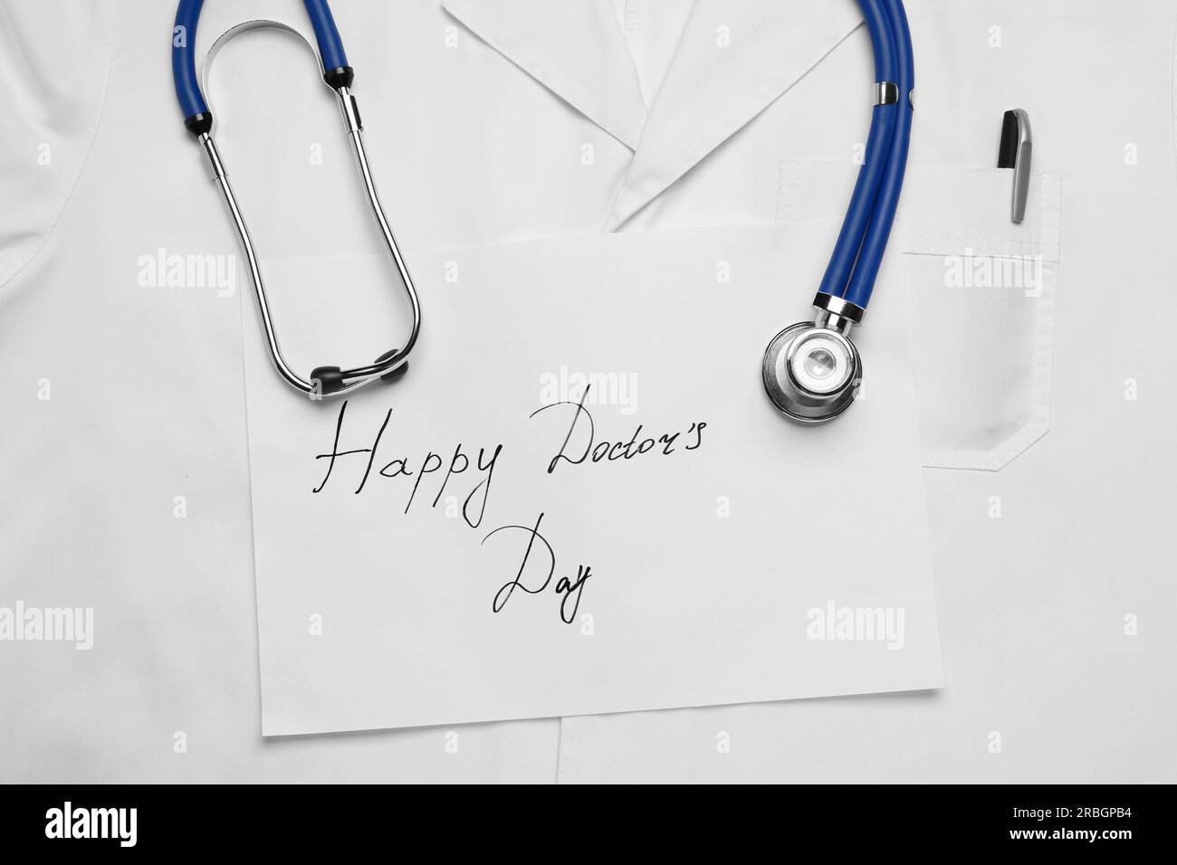 Stethoscope and paper sheet with phrase Happy Doctor's Day on white ...