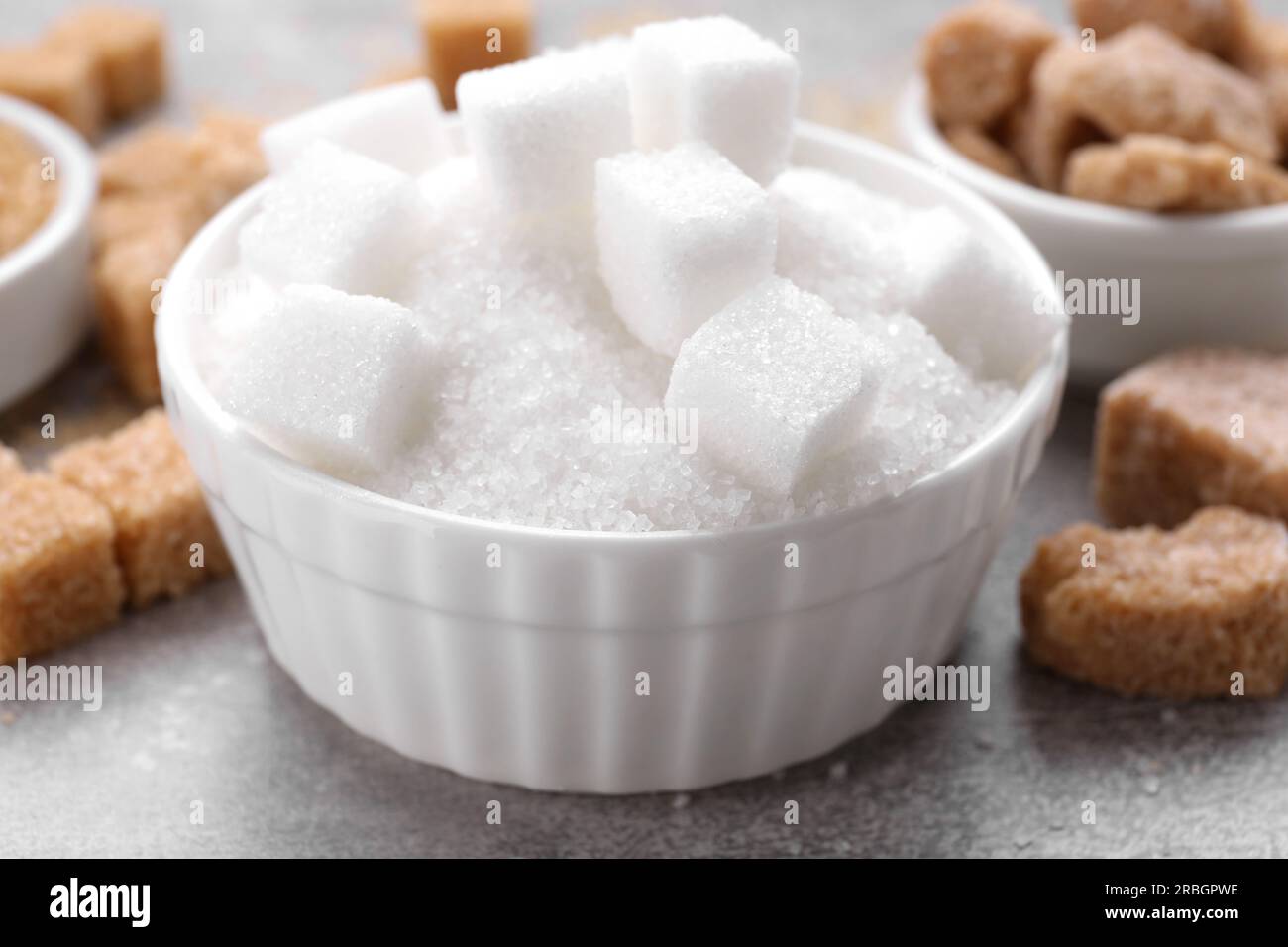 Different types of sugar on grey table, closeup Stock Photo - Alamy