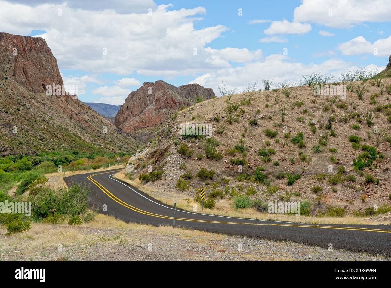 Two lane highway cut through green Rio Grande river basin in springtime ...