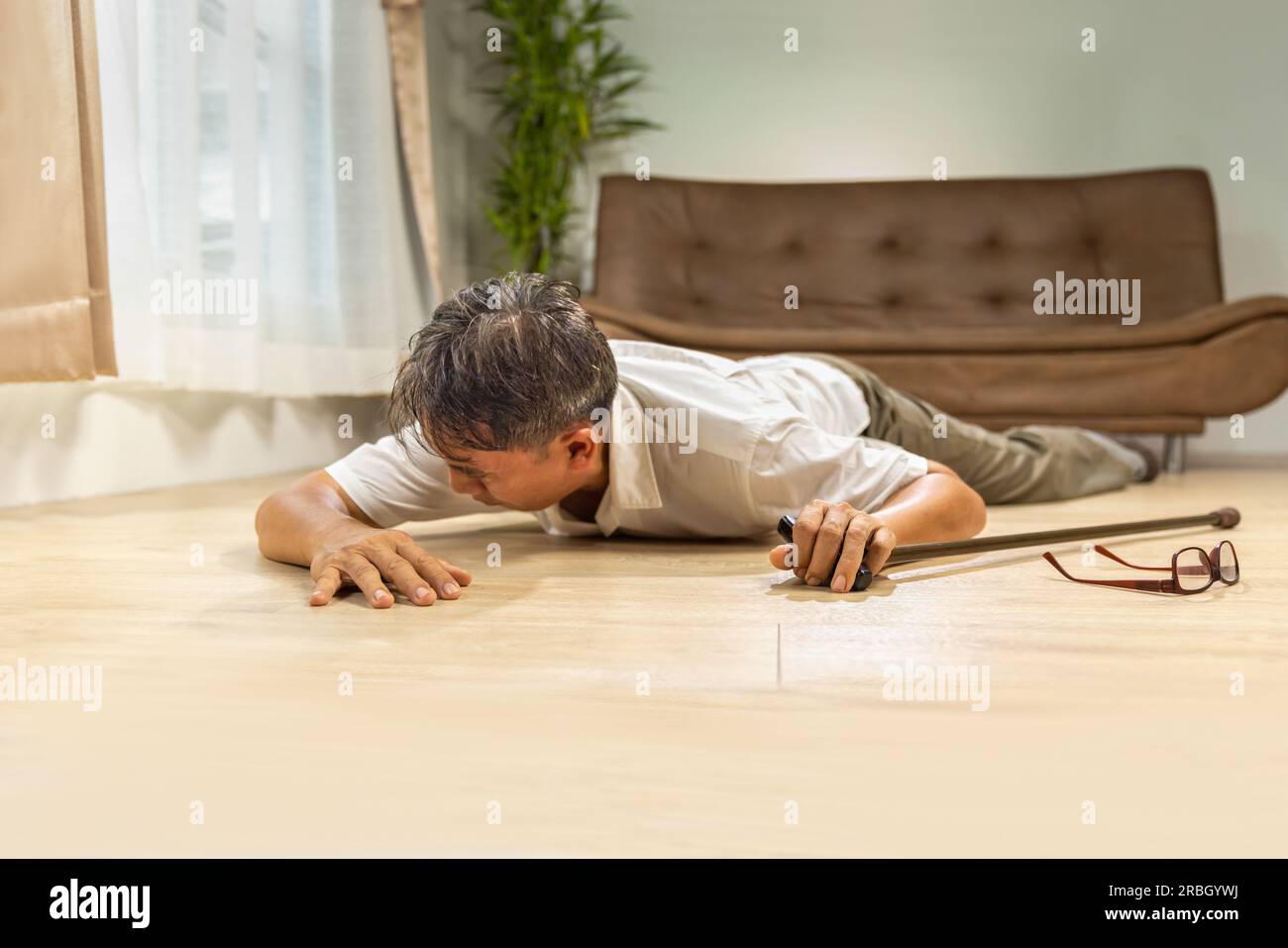 Asian senior man falling down and lying on the floor while walk with ...