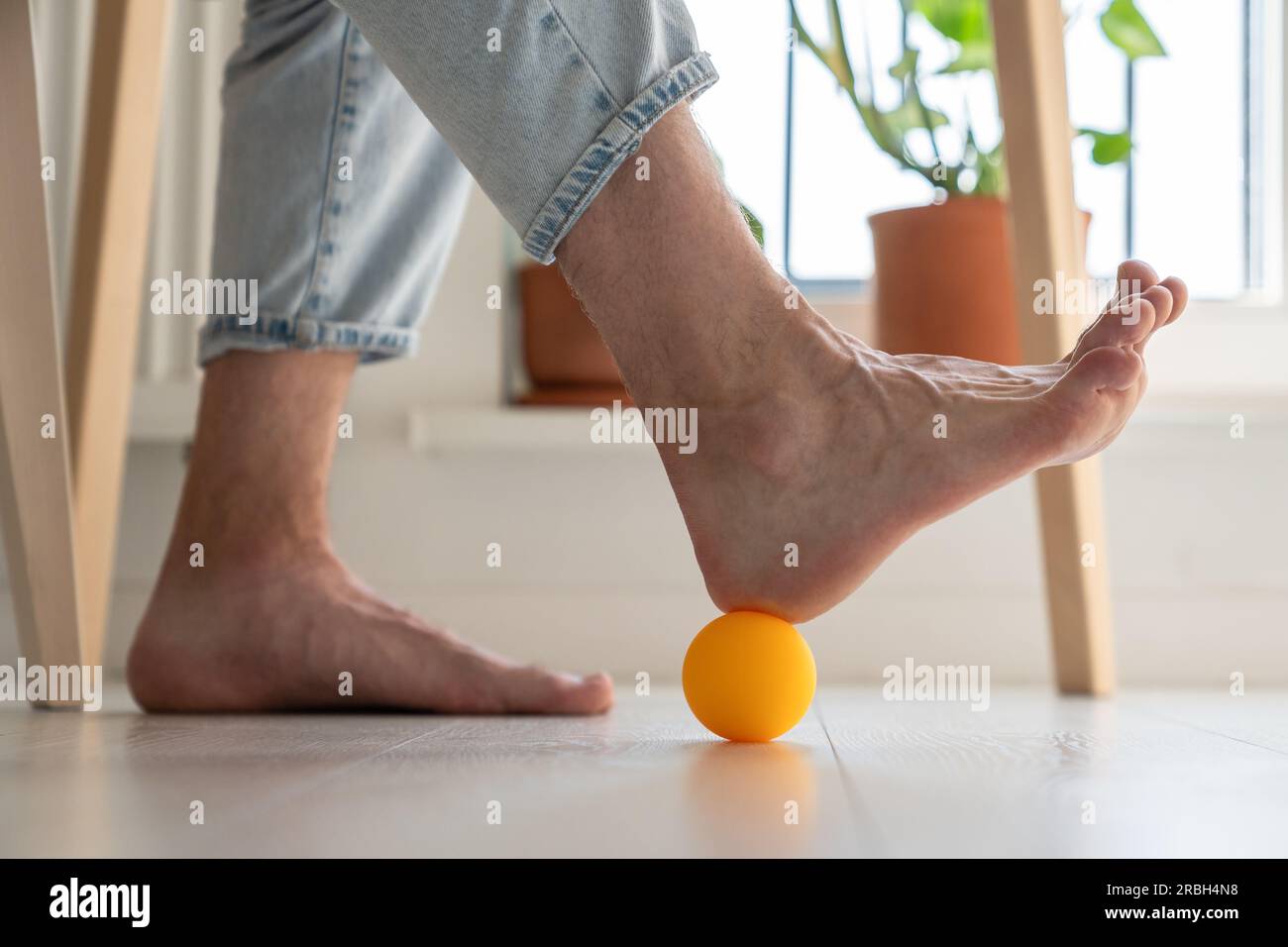 Man rolling small silicone ball under foot, massaging feet to improve ...