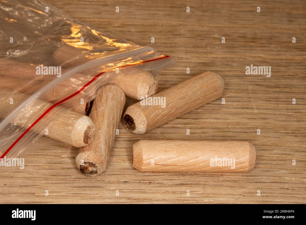 bag of oak dowel pins on oak background, dowel pins used to join two ...
