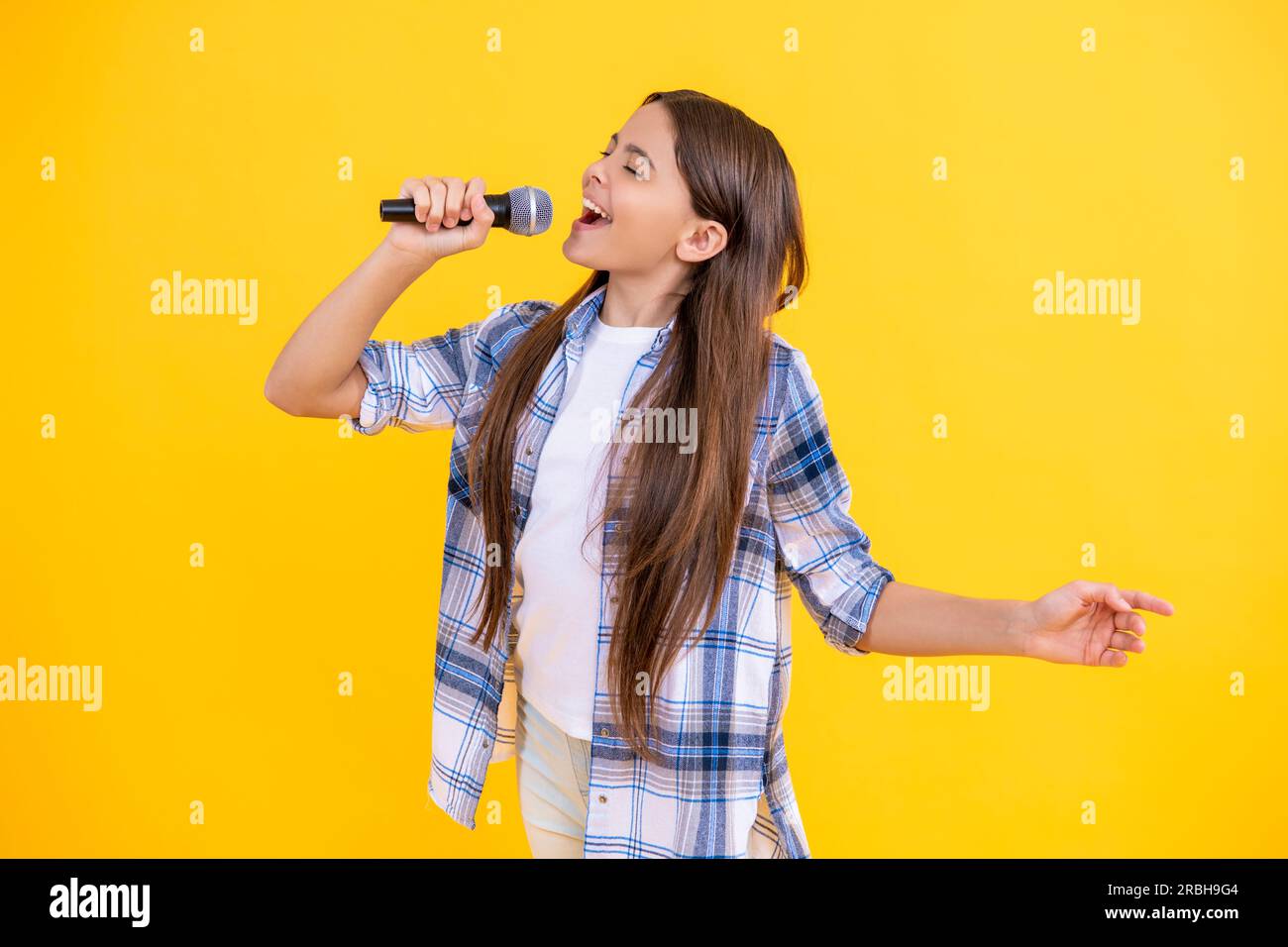 With microphone in hand positive teenage girl singer. young karaoke ...