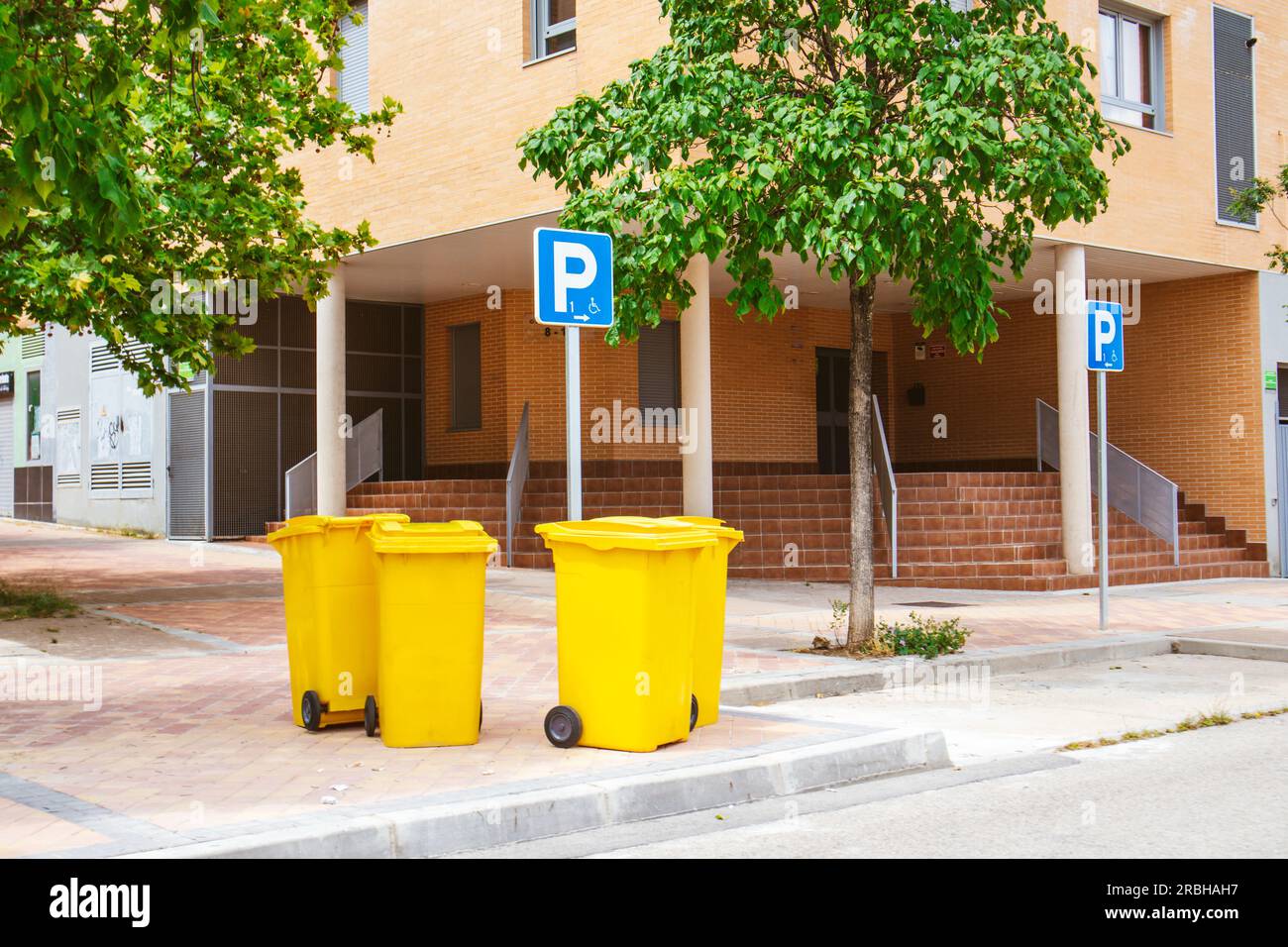 Yellow plastic trash cans on street Apartment buildings Residential ...