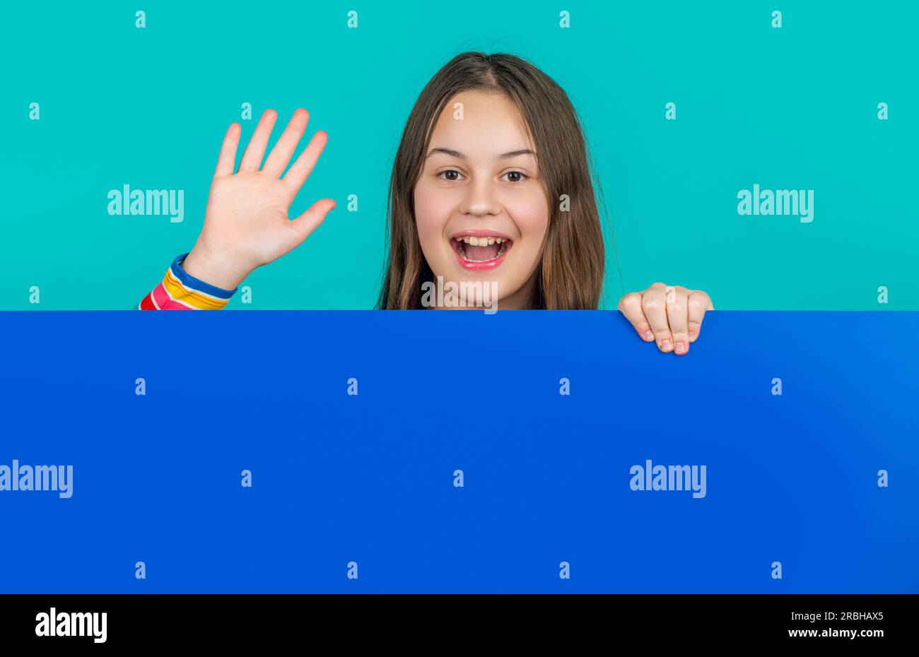happy child behind blank blue paper with copy space for advertisement ...