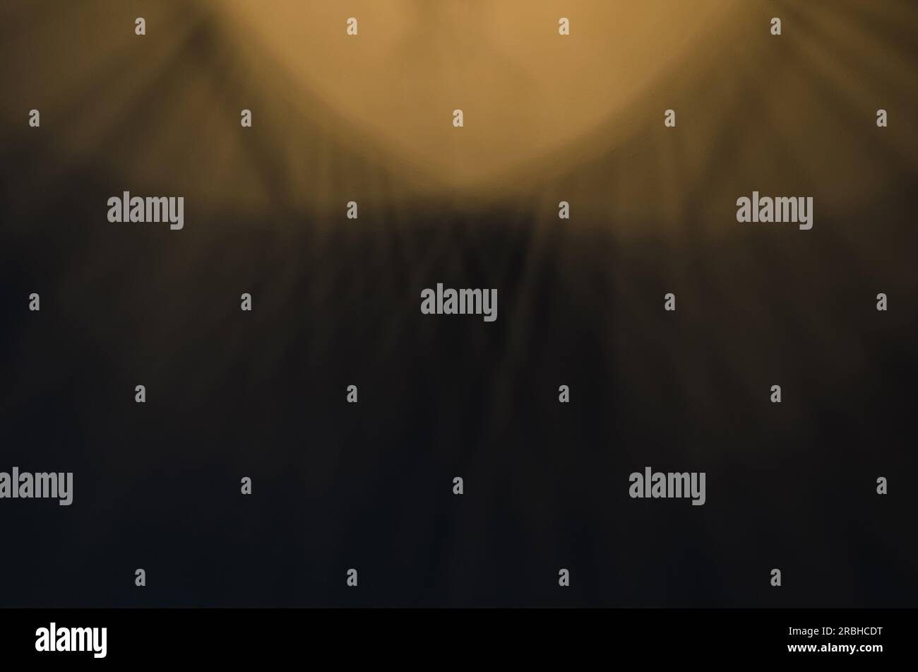 Blurred focus background of light shining to the ceiling in dark room ...