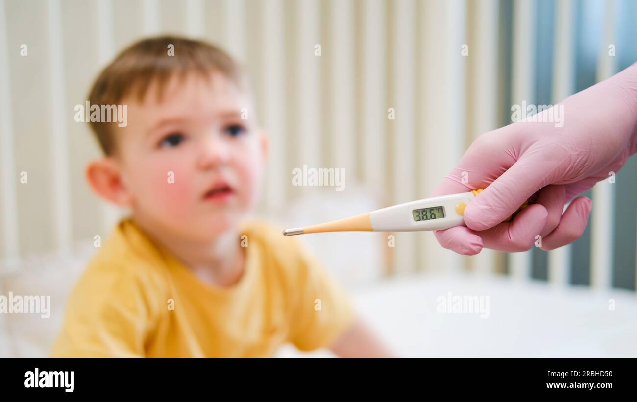 The nurse is taking the temperature of the kid using a thermometer ...