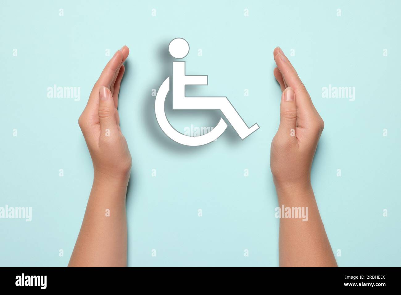 Disability inclusion. Woman protecting wheelchair symbol on light blue ...