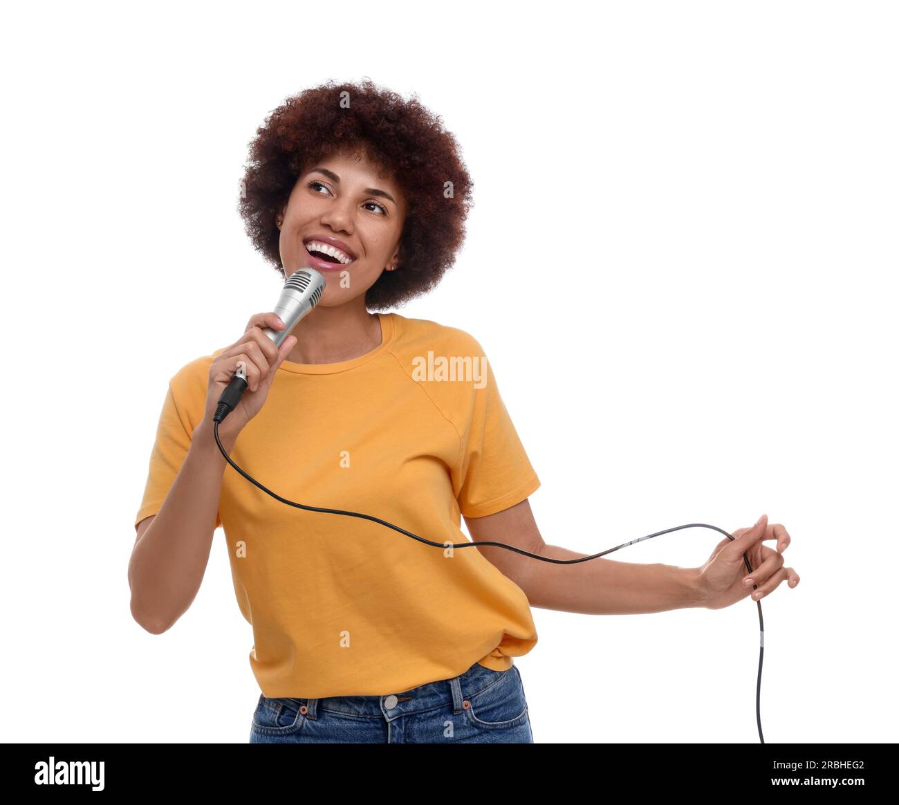 Curly young woman with microphone singing on white background Stock ...