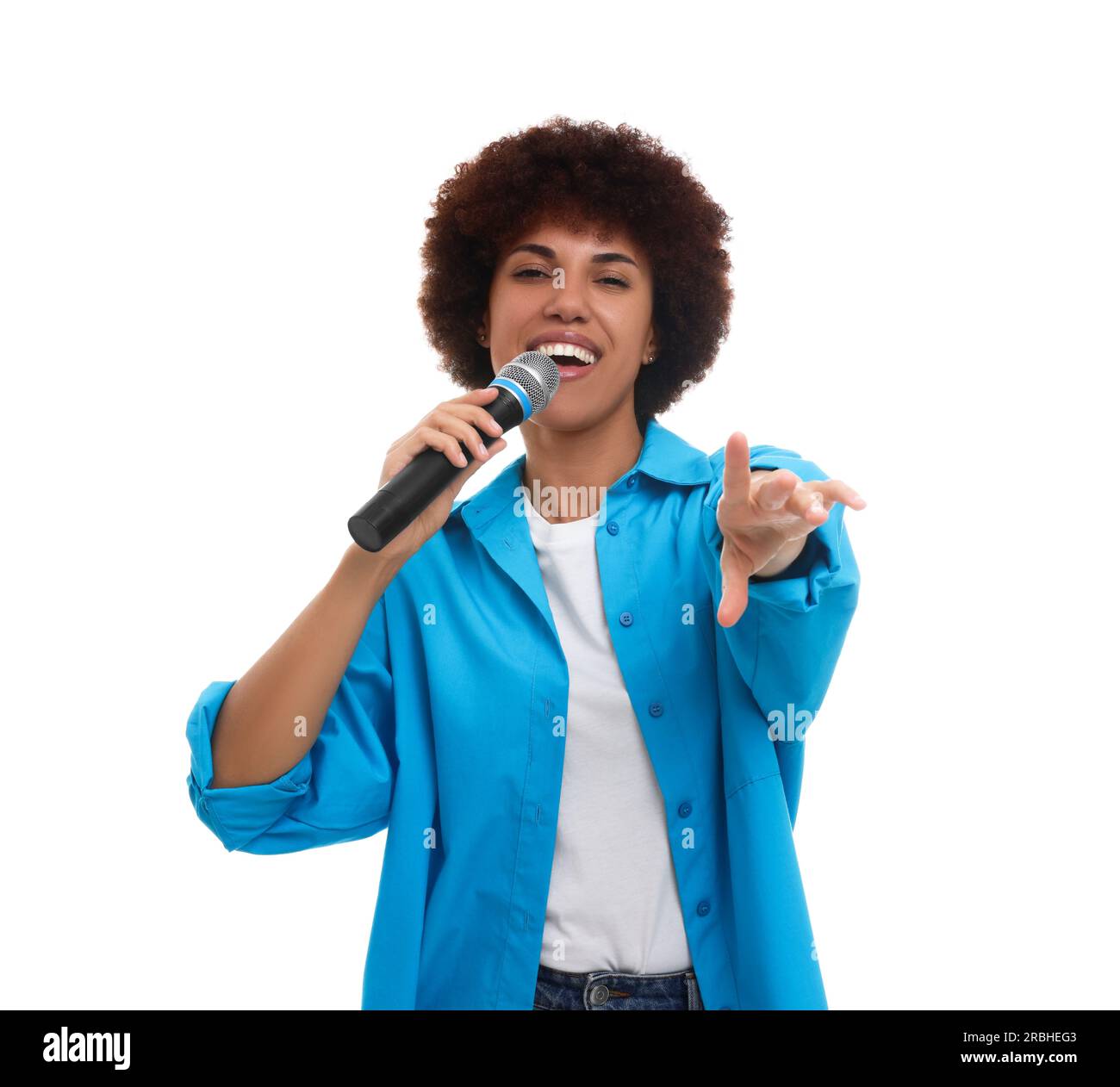 Curly young woman with microphone singing on white background Stock ...