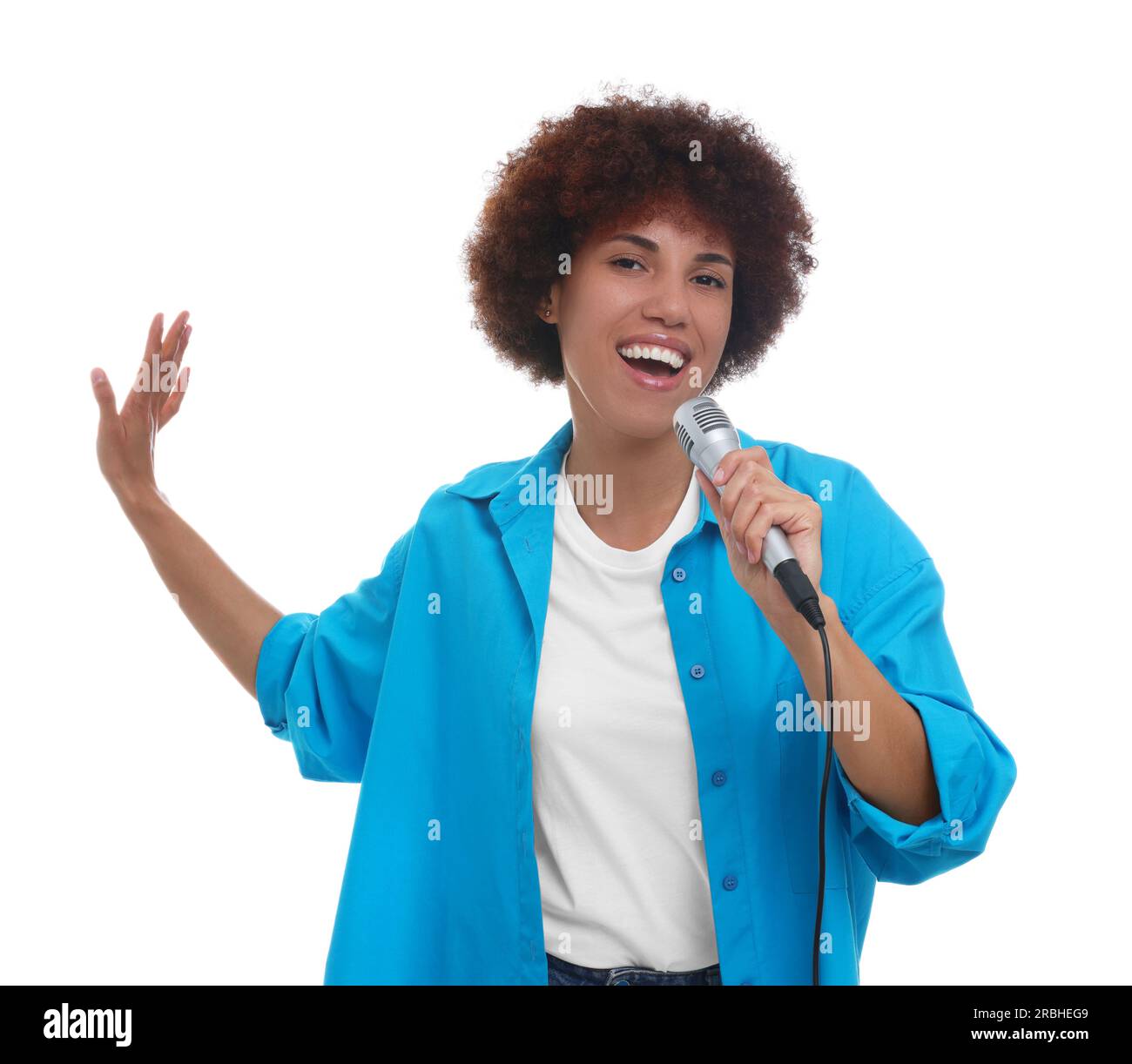 Curly young woman with microphone singing on white background Stock ...