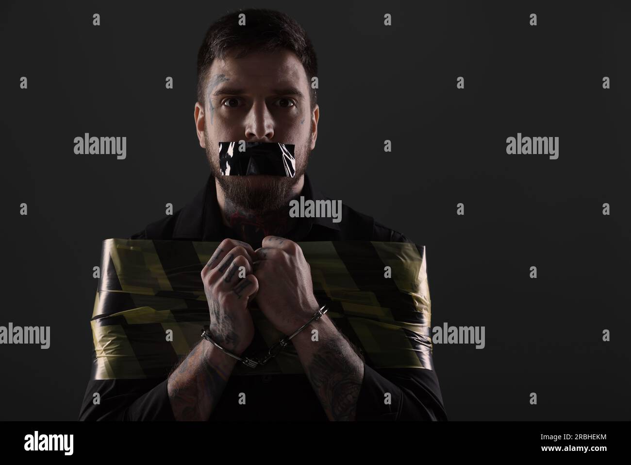 Man taped up and taken hostage on dark background. Space for text Stock ...