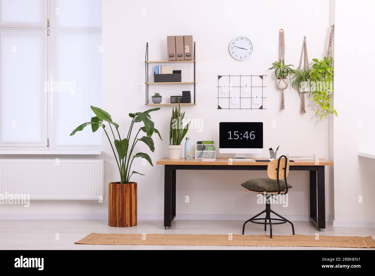 Cozy workplace with computer, modern furniture and houseplants at home ...