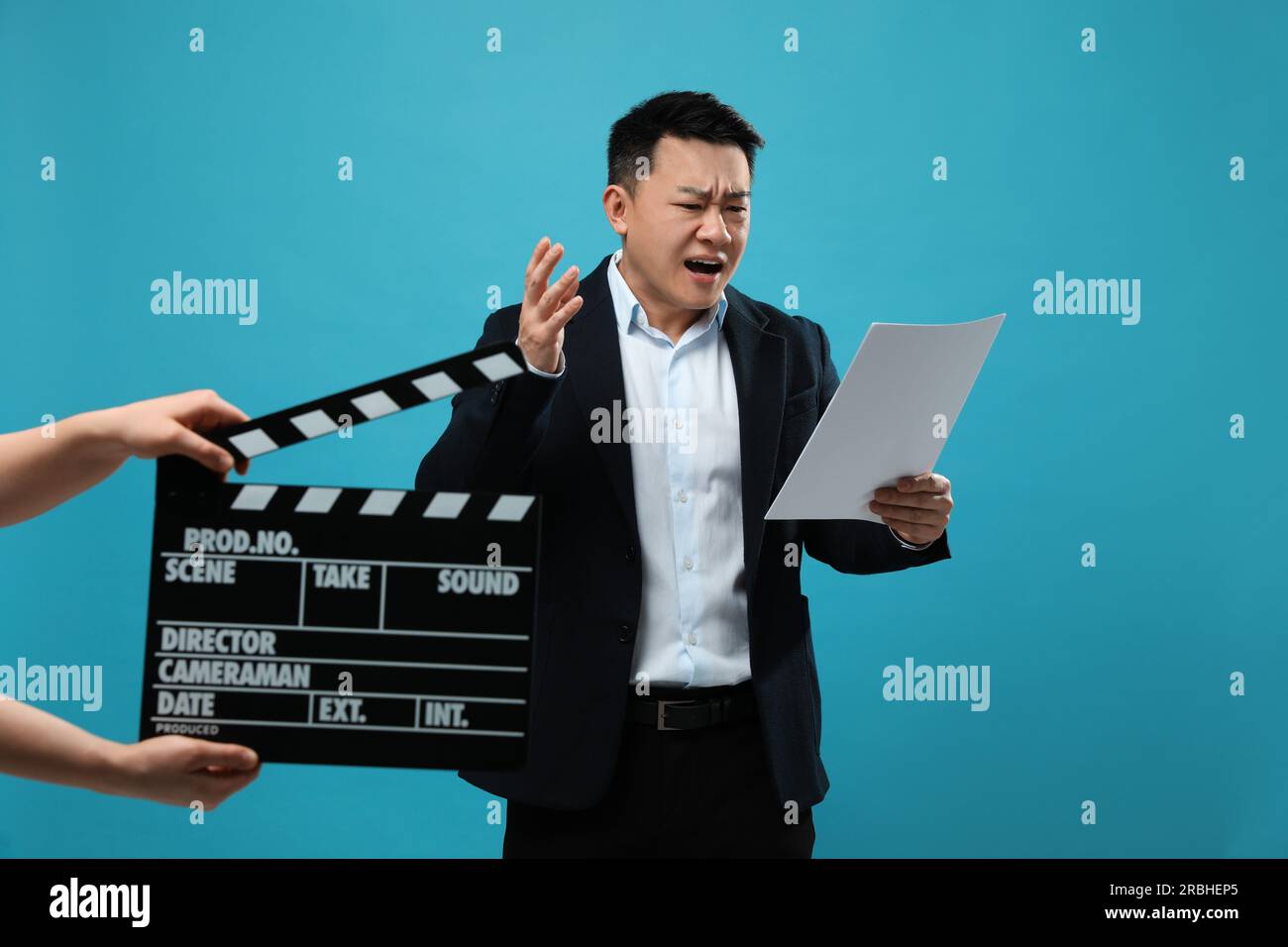 Emotional asian actor with script performing while second assistant ...