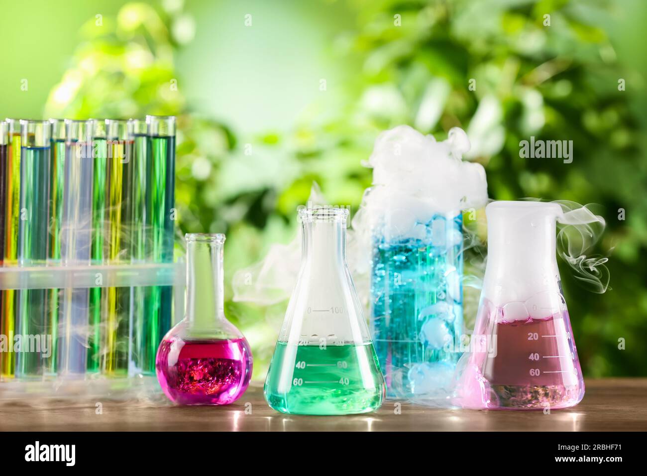 Laboratory glassware and test tubes with colorful liquids on wooden ...
