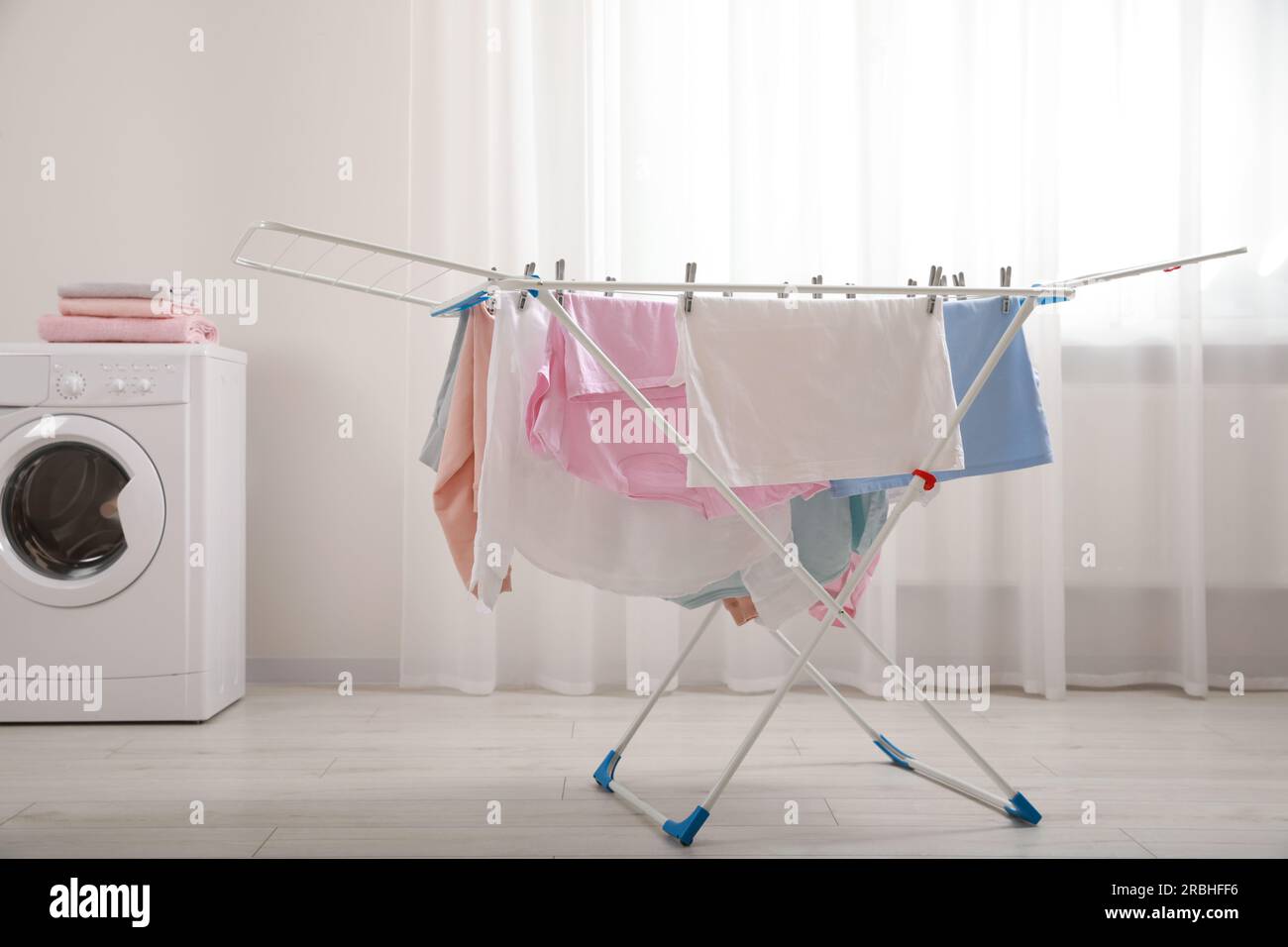 Clean laundry hanging on drying rack indoors Stock Photo - Alamy
