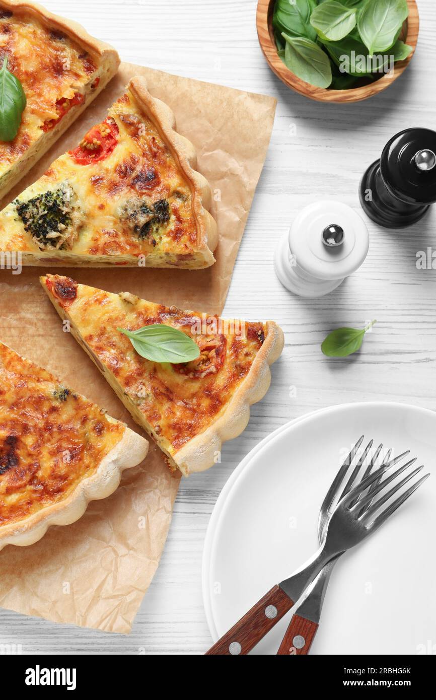 Delicious homemade vegetable quiche, spices and forks on white wooden ...