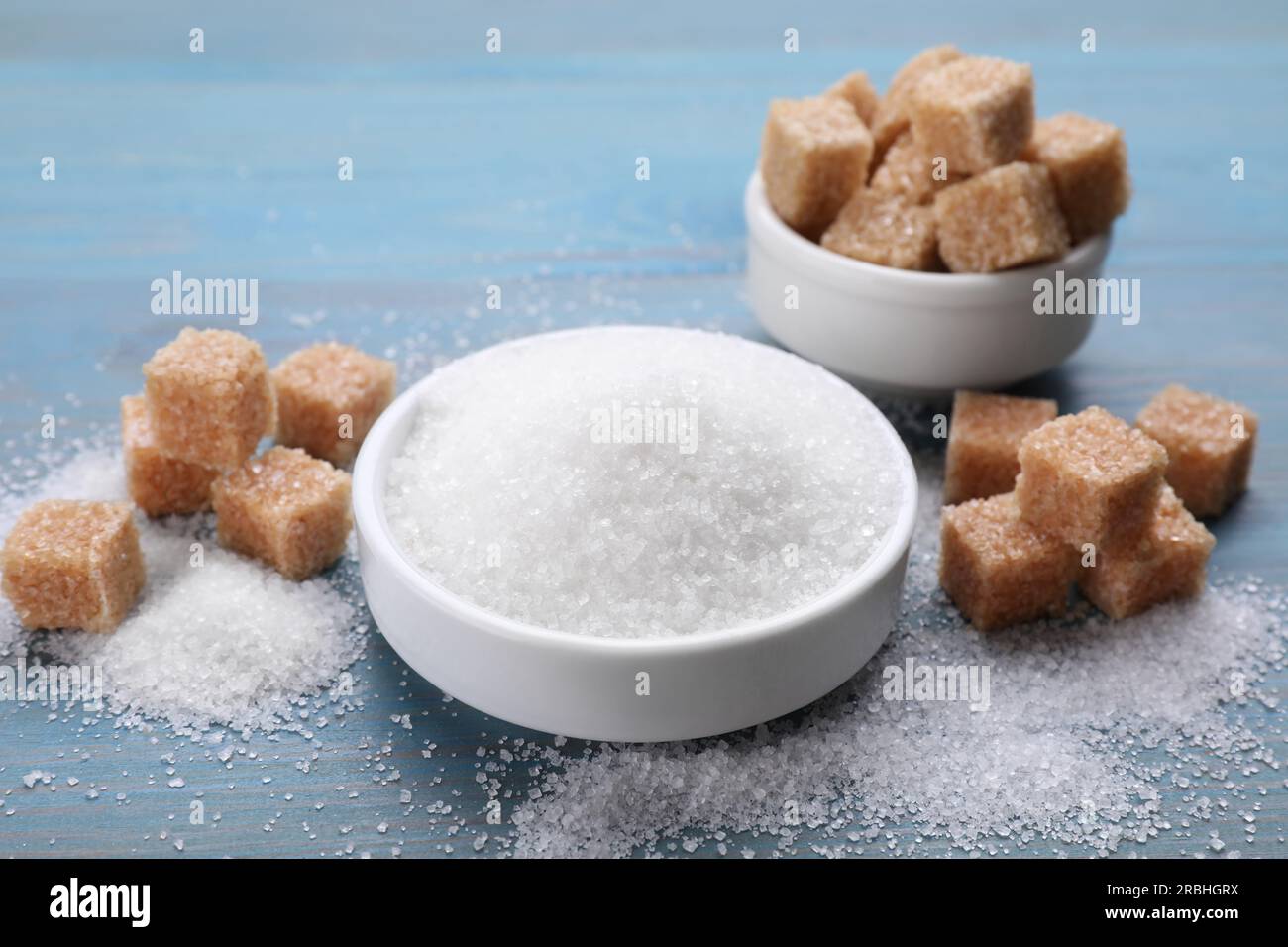 Different types of sugar on light blue wooden table Stock Photo - Alamy