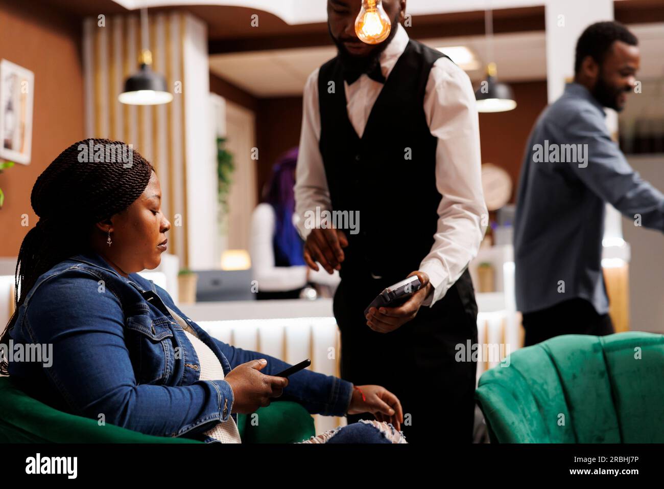 African American man hotel waiter holding POS terminal receiving ...