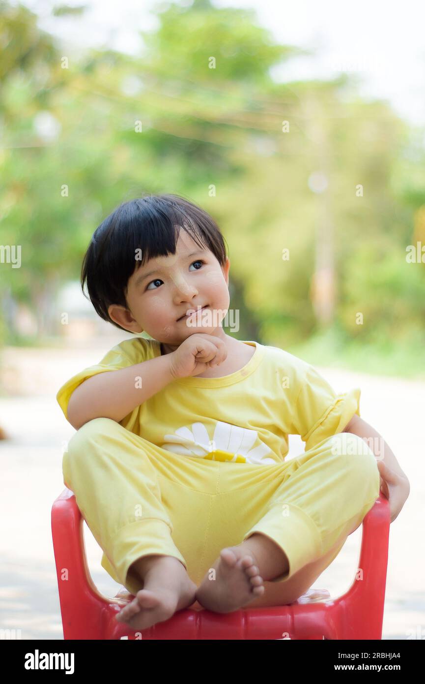a kid is sitting on chair alone and looking up Stock Photo - Alamy
