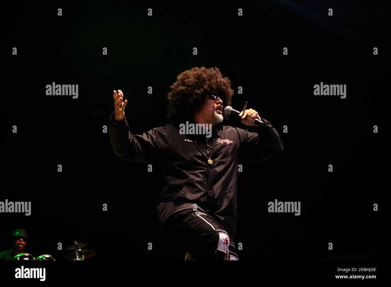 B-Real of Cypress Hill performs on stage sporting sunglasses, a large ...