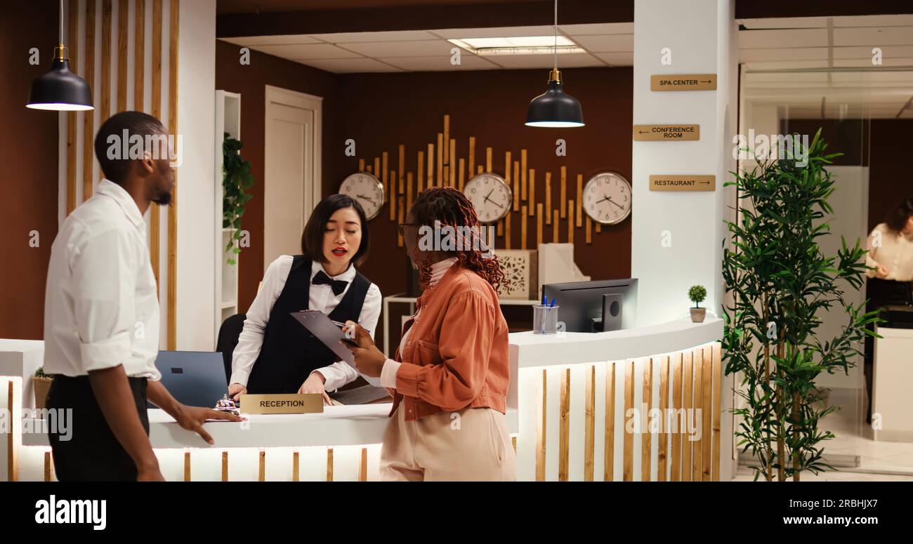 Busy concierge personnel performing various administrative tasks in ...