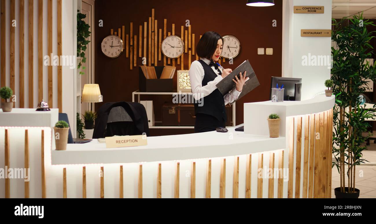 Professional hotel personnel doing administrative tasks in stylish ...