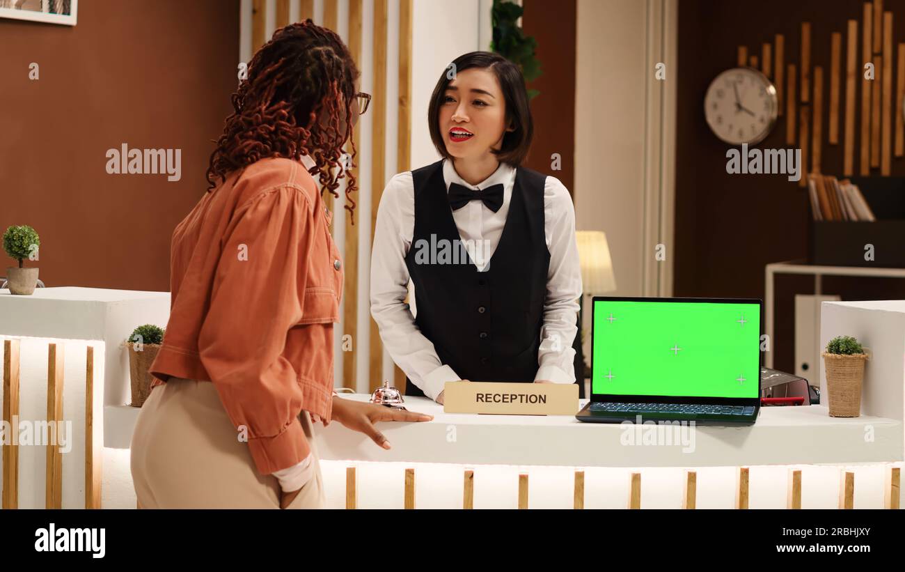 Tourist ringing concierge bell next to chroma key green screen mock up ...