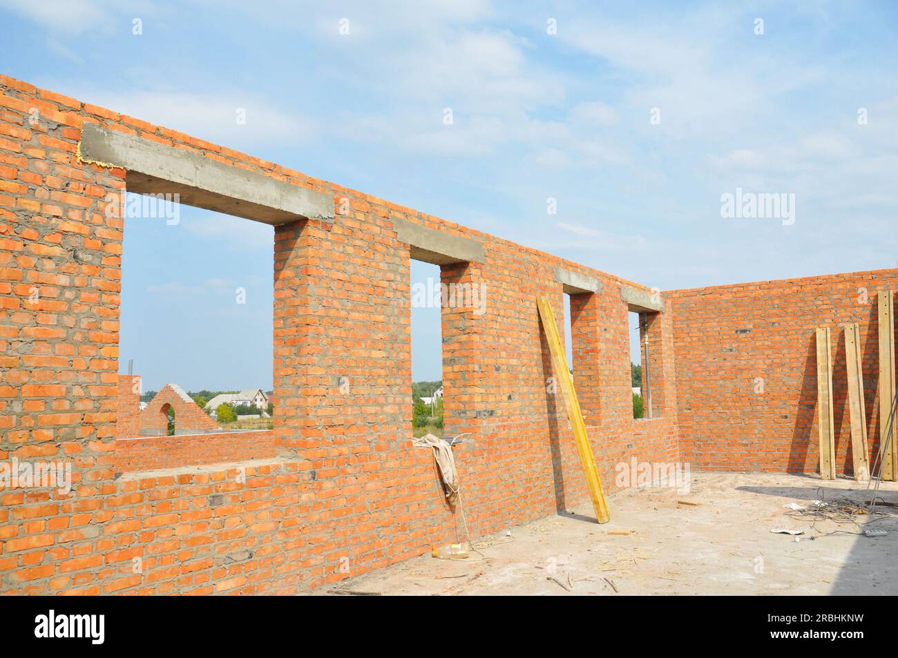 Unfinished brick house construction with windows, concrete lintels and ...