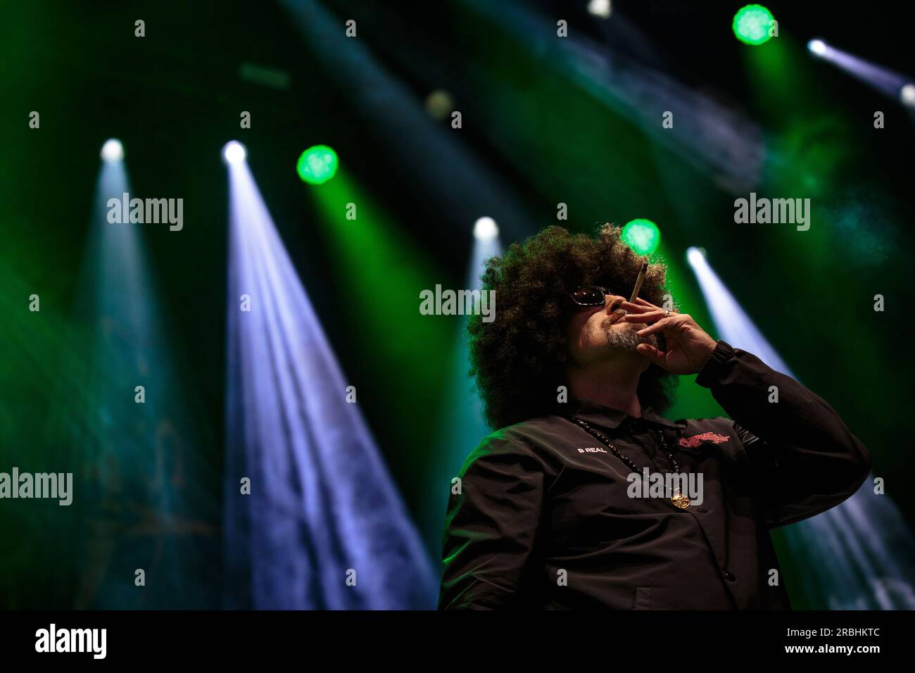 B-Real of Cypress Hill performs on stage sporting sunglasses, a large ...