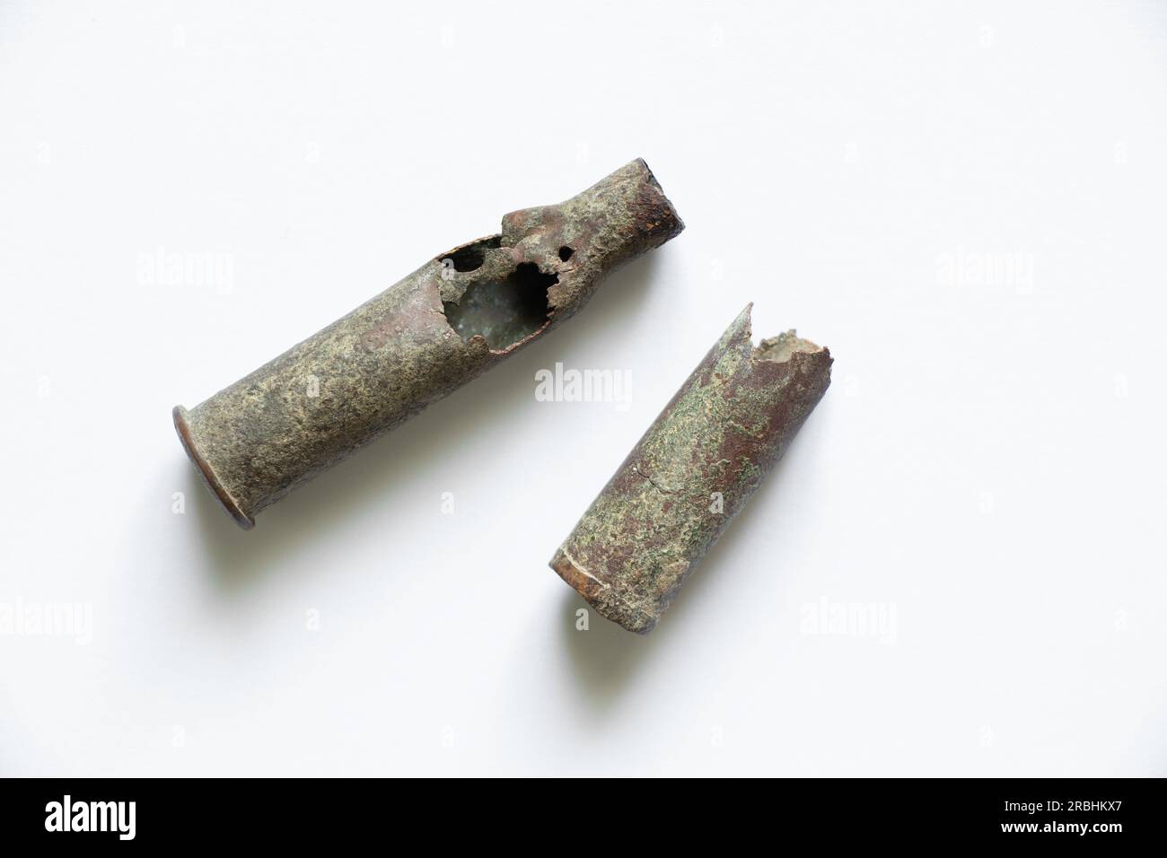 old military cartridges buried in the ground on a white background ...