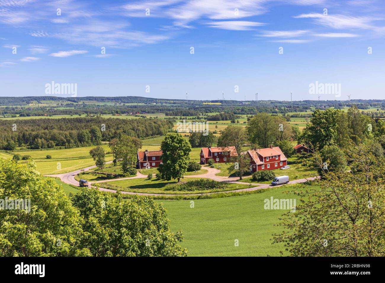 Rural landscape view with red houses by a road with cars Stock Photo ...