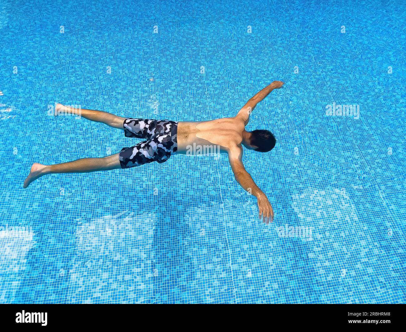 Drowned man floating in indoor swimming pool water, conceptual shot ...