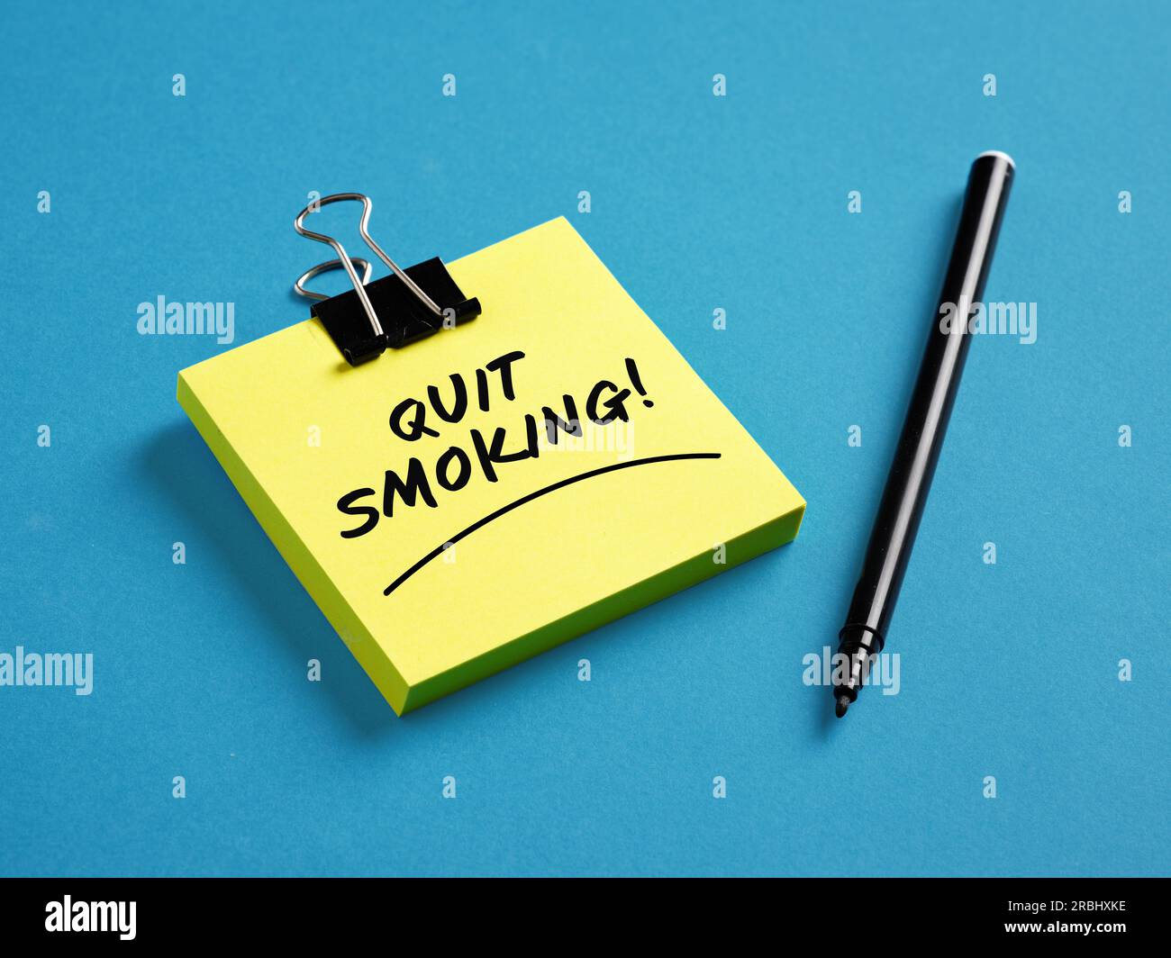 The warning message quit smoking on yellow sticky note paper with a ...